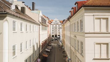 Uma rua estreita ladeada por edifícios com fachadas uniformes e um edifício central com uma cúpula imponente.