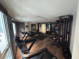 Uma academia com esteiras, halteres e equipamentos de musculação.
