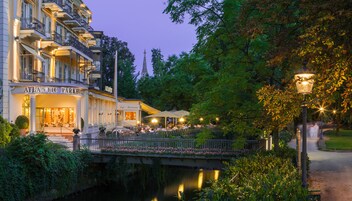 Exterior do Hotel Atlantic Park, com um café, uma ponte sobre um canal e vegetação ao redor.
