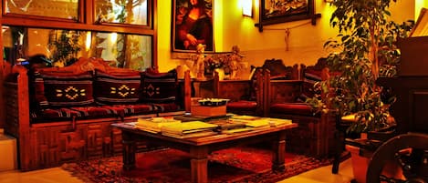 Uma sala de estar acolhedora com um sofá, uma mesa de centro e uma pintura grande da Mona Lisa.