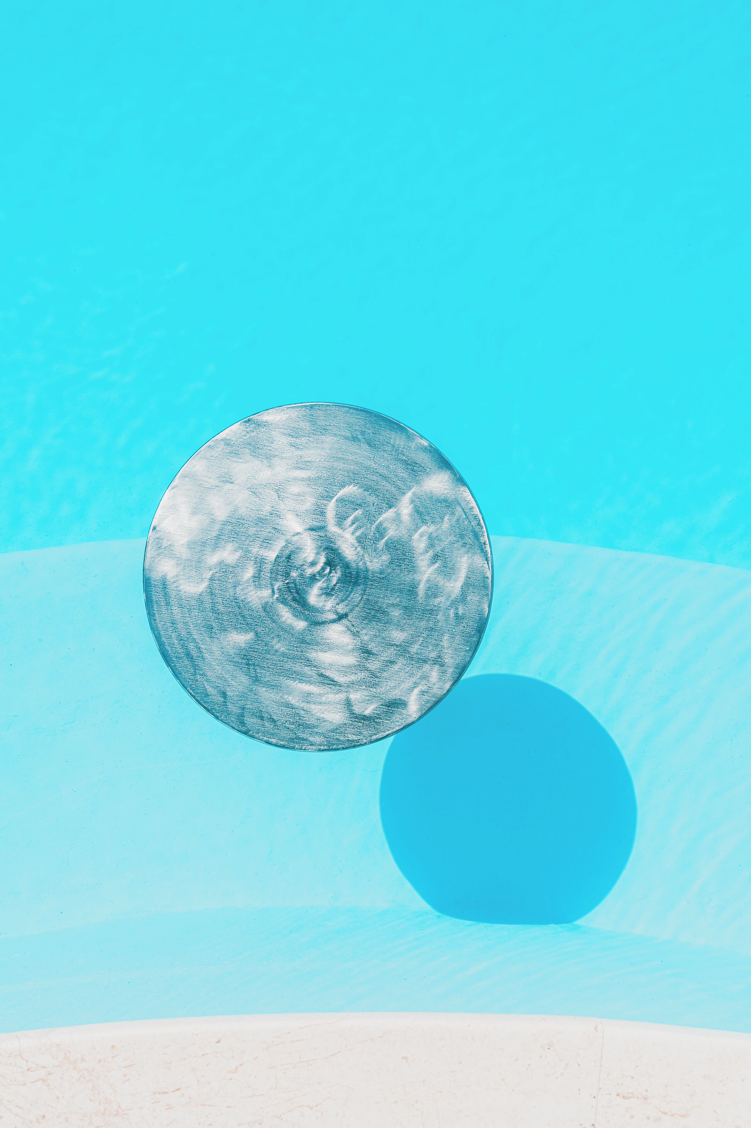 Um objeto redondo com superfície texturizada sobre um fundo azul claro.