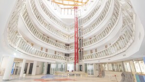 Um átrio com vários níveis, espaço aberto central e teto de vidro.