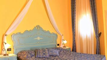 Quarto com cama de dossel, duas mesas de cabeceira e um dossel.