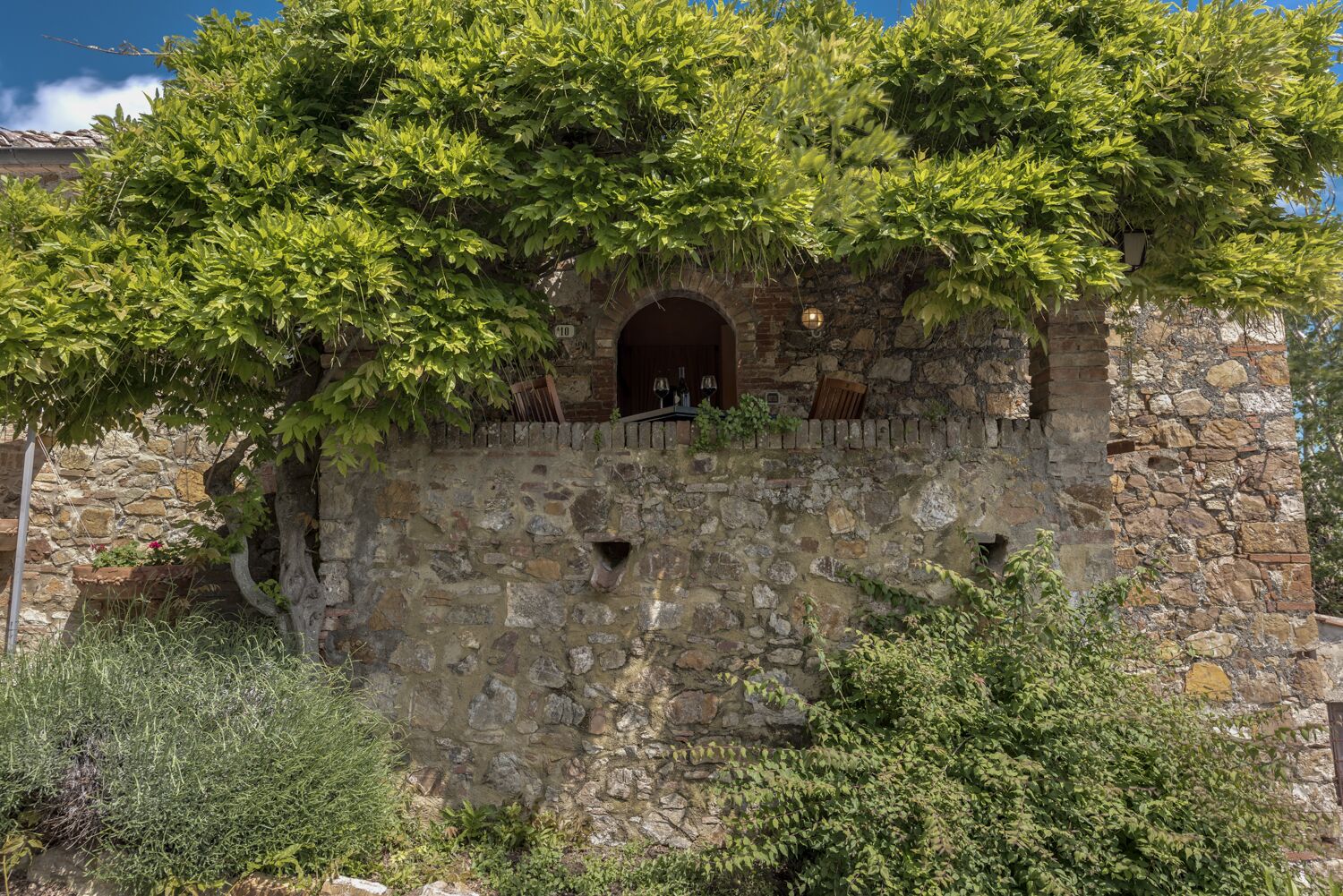 Um edifício de pedra com uma pequena janela em arco e uma porta de madeira.