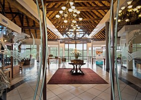Um hall amplo com teto alto, um candelabro e vista para o exterior.