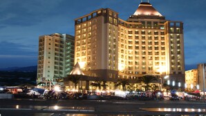 Um hotel de vários andares com uma torre de esquina imponente e um teto em forma de cúpula.