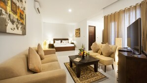 Quarto de hotel moderno com sala de estar, quarto e banheiro.