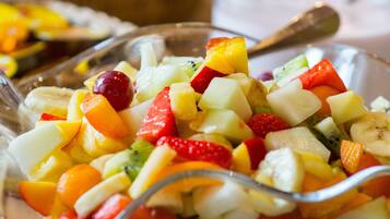 Uma tigela de vidro cheia de uma salada de frutas colorida.