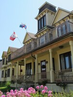 Um edifício de dois andares com varanda e mastro.