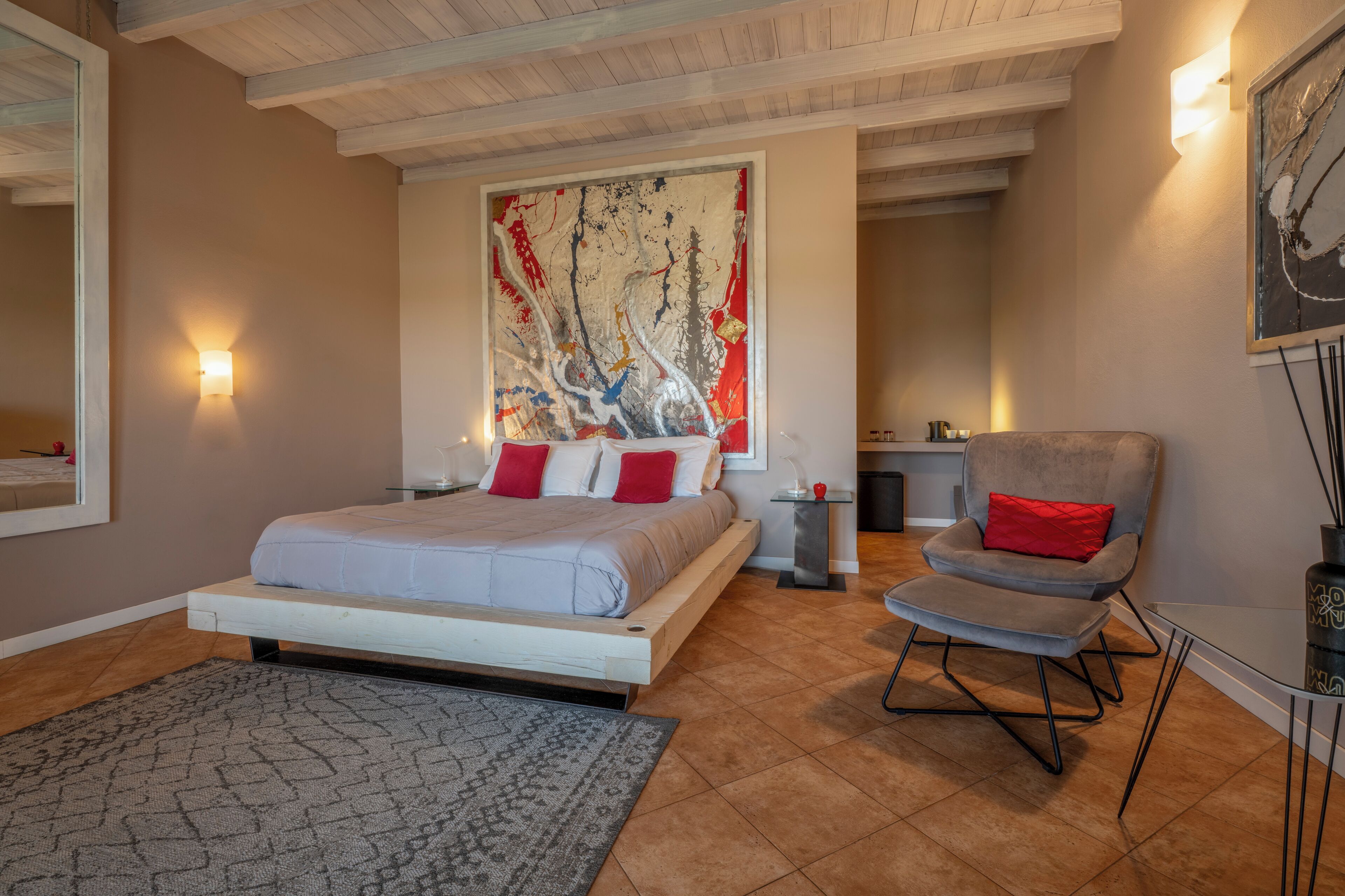 Quarto moderno com uma cama grande, uma cadeira, um tapete e um quadro na parede.
