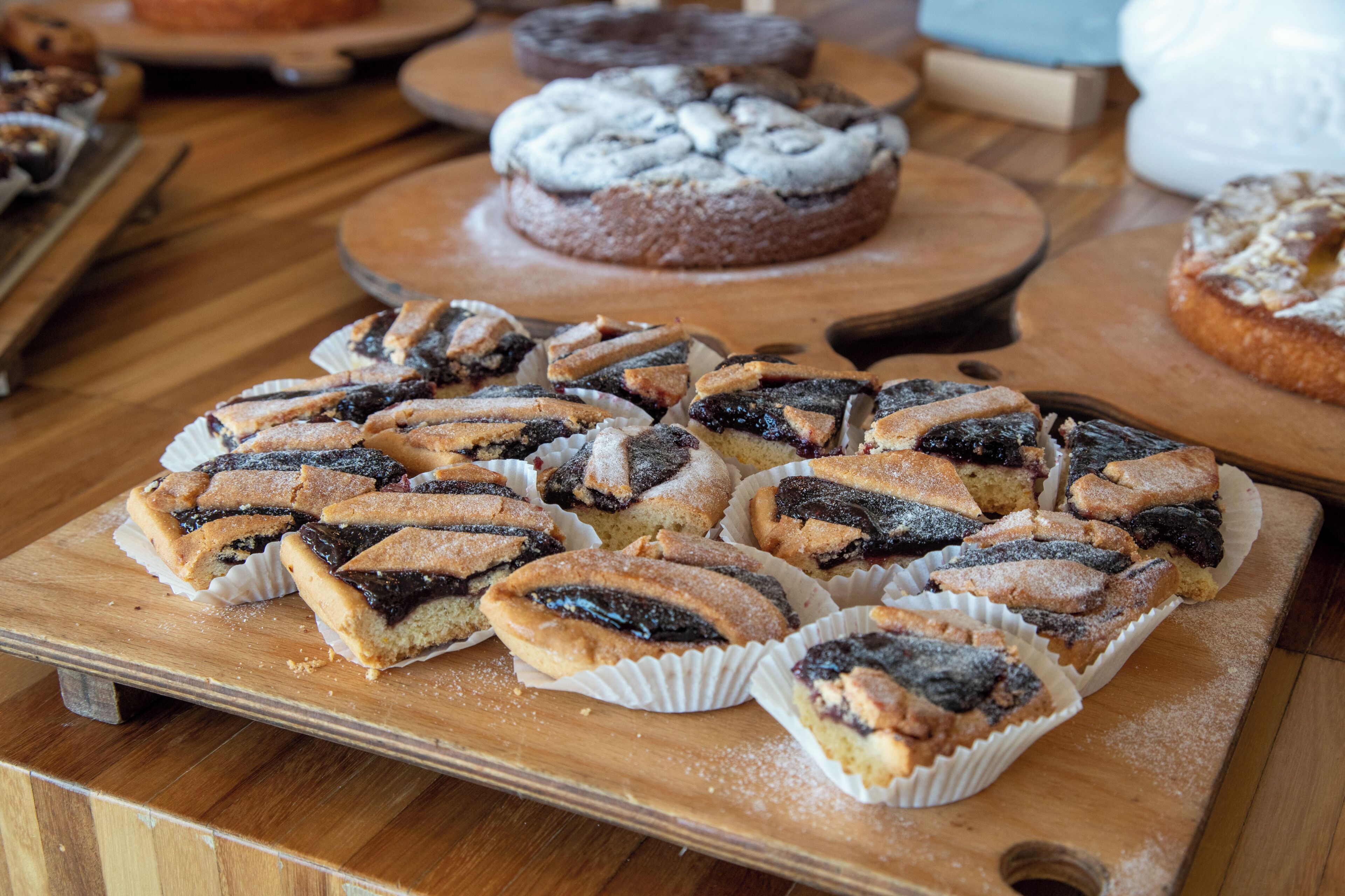 Uma mesa de madeira com diversos doces e sobremesas.