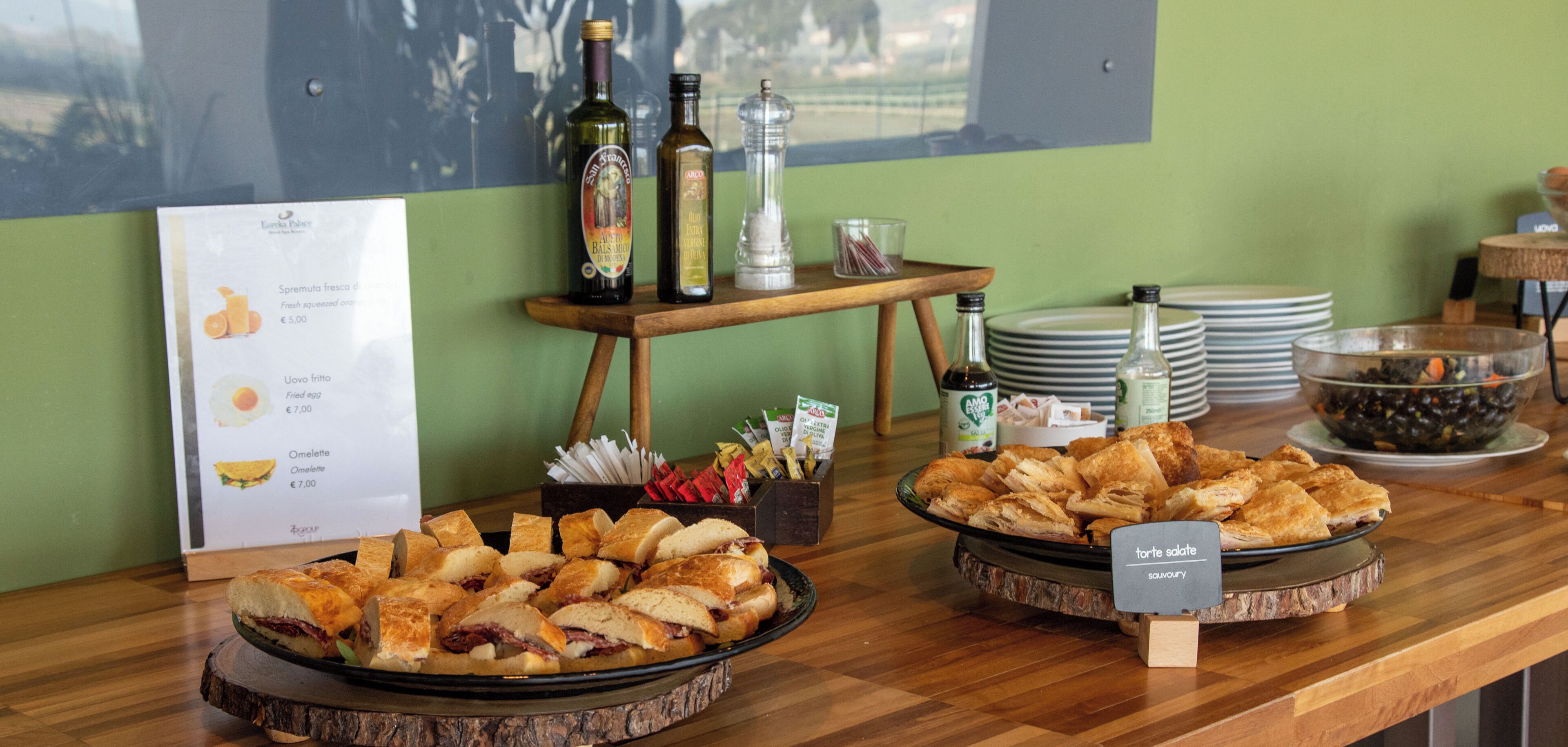 Buffet com sanduíches, doces e acompanhamentos.