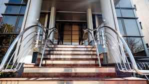 Um conjunto de degraus de mármore com corrimãos de metal que levam à entrada de um edifício.