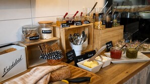 Um buffet de café da manhã com diversos alimentos e acompanhamentos.