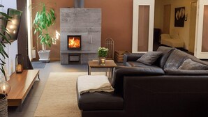 Uma sala de estar moderna com lareira, um sofá, uma mesa de centro e um vaso de planta.