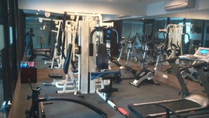 Uma academia com diversos equipamentos de exercício, incluindo esteiras, bicicletas ergométricas e aparelhos de musculação.