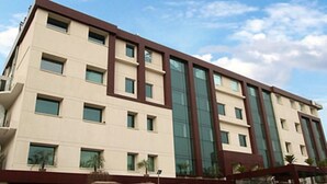 Um hotel de vários andares com design arquitetônico moderno, caracterizado por janelas amplas e um telhado plano.
