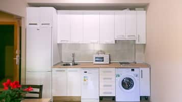 Um frigorífico, um micro-ondas, utensílios de cozinha