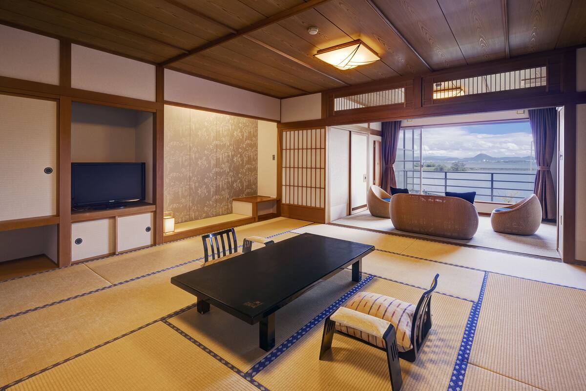 Quarto japonês tradicional com tatames, uma mesa baixa e assentos.