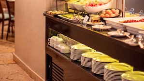 Uma mesa de buffet com diversos alimentos e pratos.