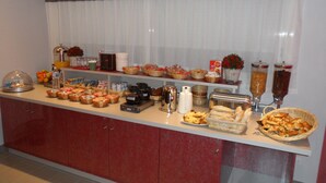 Disposição de buffet com diversos alimentos e bebidas.