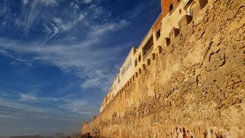 Um muro de pedra histórico com várias janelas e um telhado plano.