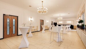 Um amplo saguão de hotel com teto alto, lustres e design moderno.