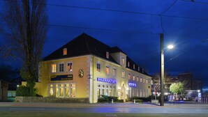Um hotel com uma placa que indica "BRAUEREIGASTSTÄTTE" e "Wiener Platz", revelando sua localização.