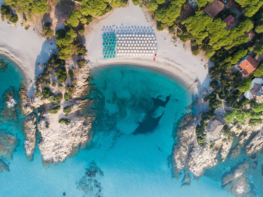 Perto da praia, areia branca, espreguiçadeiras, guarda-sóis