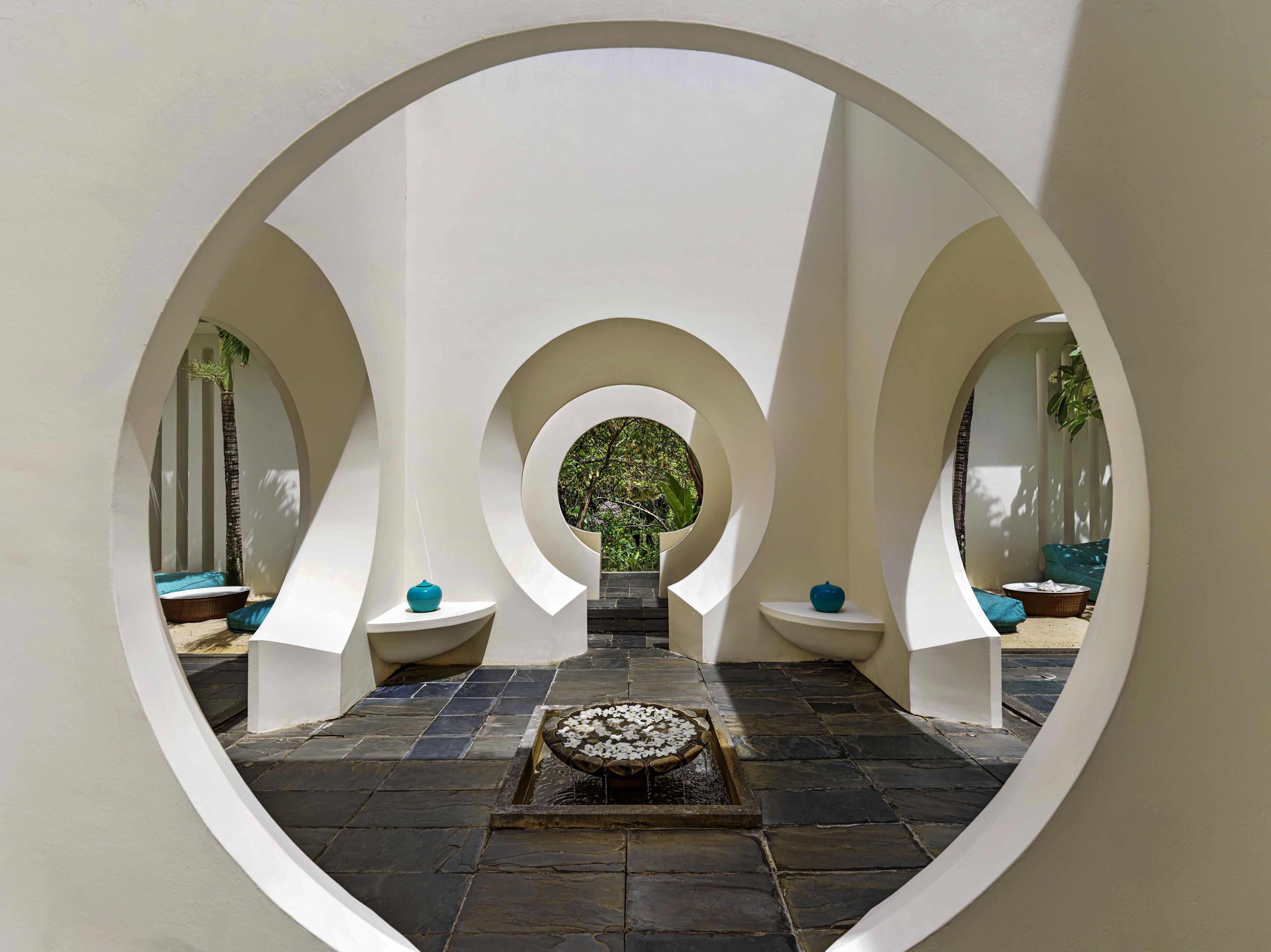 Um design arquitetônico circular com um elemento central de água e áreas de estar.
