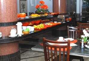 Uma área de buffet com diversos tipos de comida e um espaço para café.