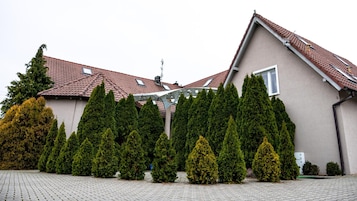 Uma casa moderna com telhado ladrilhado, diversos claraboias e entrada com calçada.