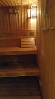 Uma sauna de madeira com bancos e piso inclinado.