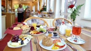 Buffet de café da manhã com diversos alimentos e bebidas.