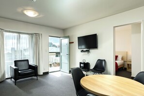 Apartamento superluxo, 2 camas Queen, vista parcial para o oceano | Área de estar | Smart TV 43 polegadas com canais digitais, TV