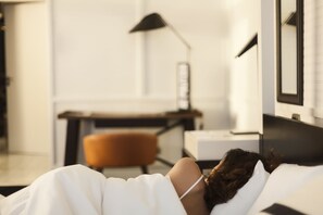 Quarto com cama, escrivaninha e cadeira.