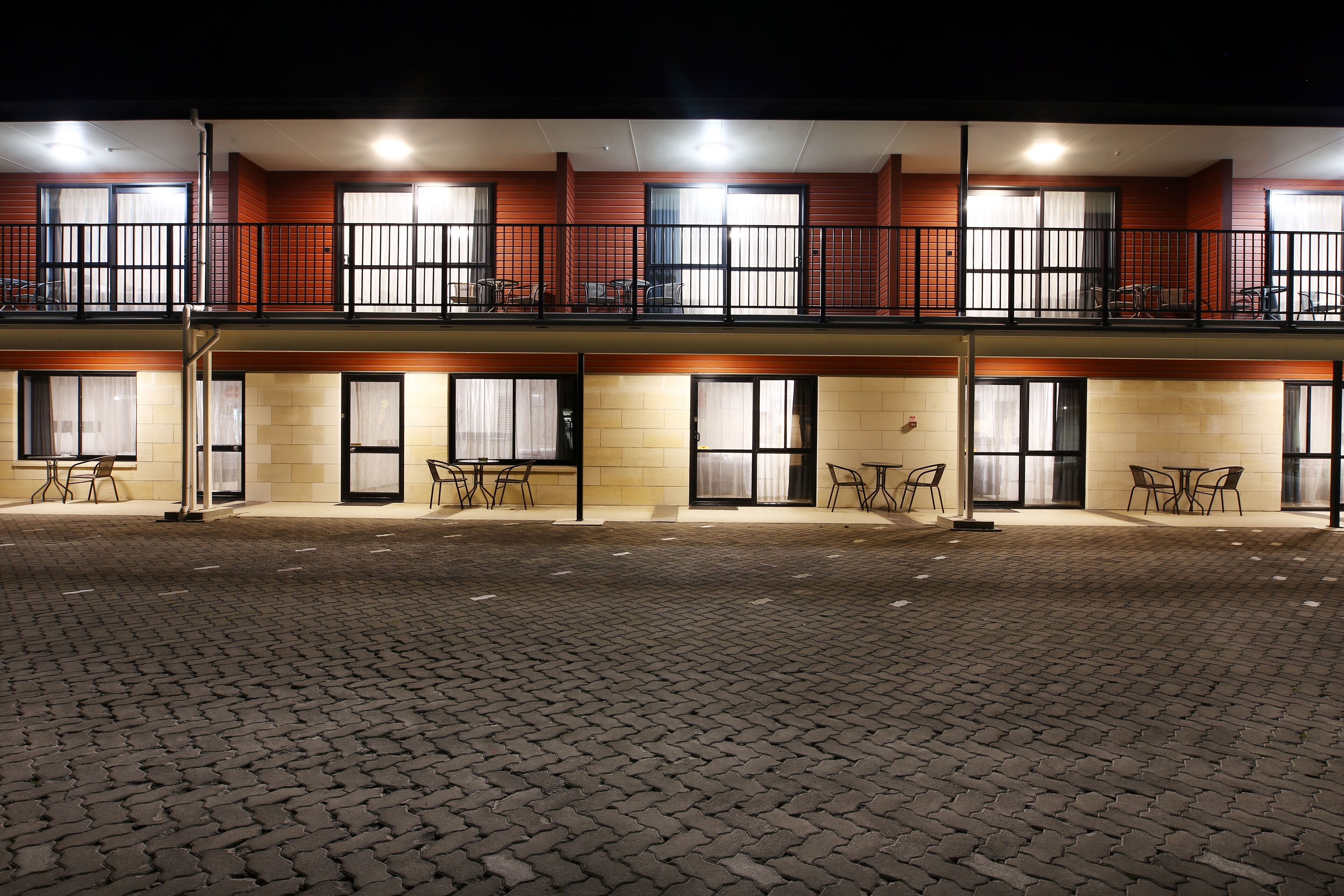 Um hotel com fachada de tijolos, várias varandas e áreas de estar ao ar livre.