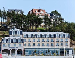 Um hotel com várias varandas, uma marina e um edifício com telhado vermelho.