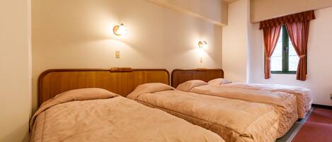 Quarto de hotel com duas camas, cabeceiras de madeira e luminárias fixadas na parede.