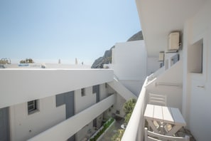 Um edifício moderno com várias varandas, área de estar ao ar livre e vista para o mar.