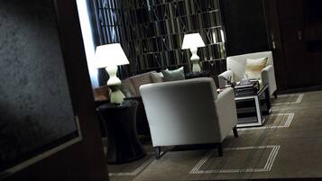 Um hall de hotel moderno com um sofá, poltronas e uma mesa de centro.