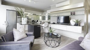 Uma sala de estar moderna com sofá, mesa de centro e televisão.
