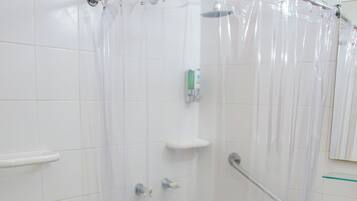 Um banheiro com chuveiro, vaso sanitário e pia.