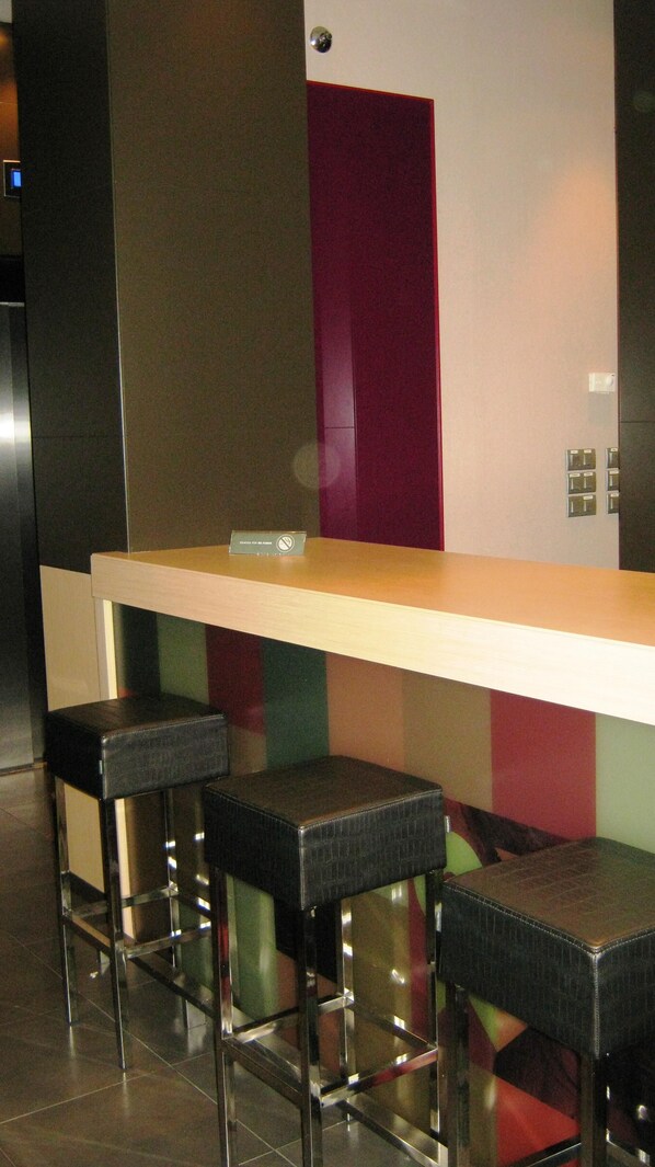 Uma área de bar com um balcão comprido e três banquetas.