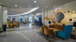 Um hall amplo com teto curvo, balcão de recepção e áreas de estar.