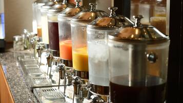 Estação de distribuição de bebidas com várias opções, incluindo sumos e café.