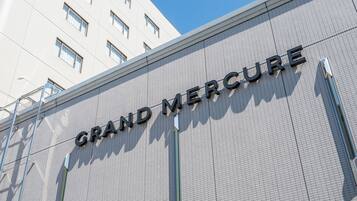 Fachada de um edifício com o nome "GRAND MERCURE" em destaque.