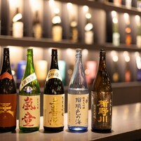Diversas garrafas com etiquetas em um balcão de bar.