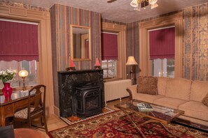 Suíte luxo, 1 cama Queen, lareira, em edifício anexo | Área de estar | TV de tela plana