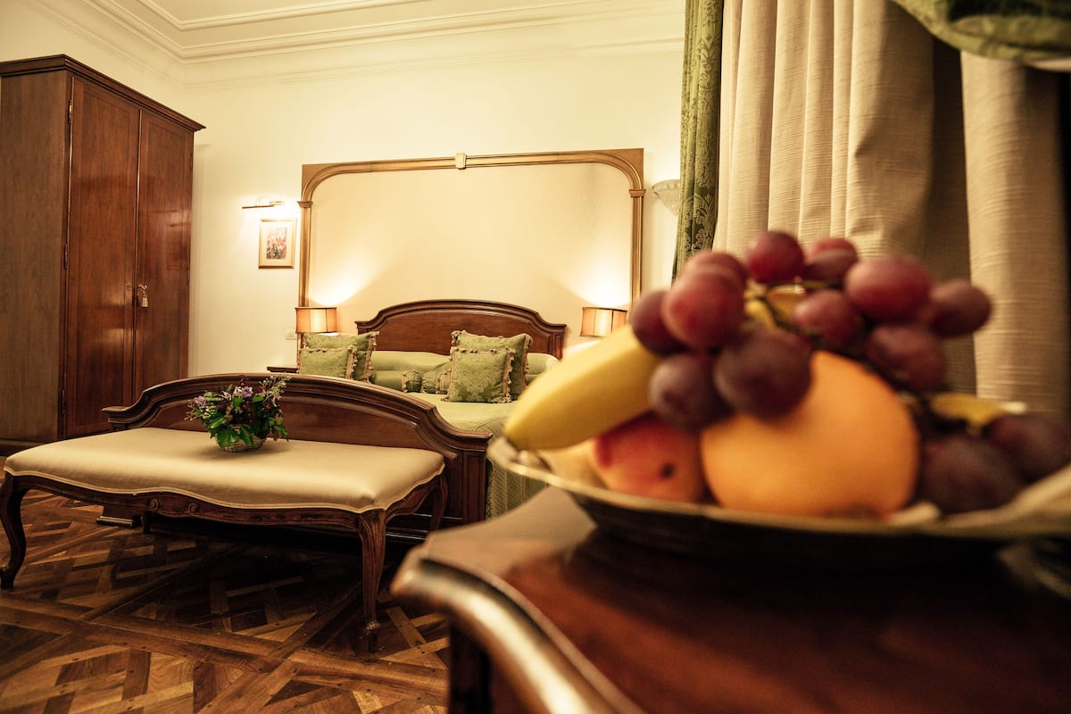 Quarto com cama de madeira, mesa de cabeceira, guarda-roupa de madeira e uma fruteira na mesa de cabeceira.